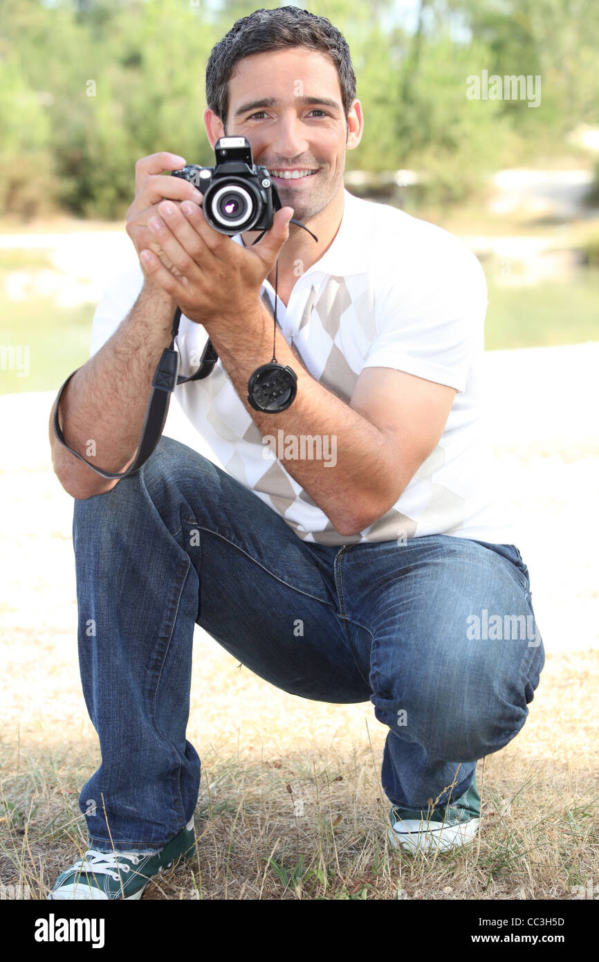 Photographer crouching in the countryside Stock Photo - Alamy