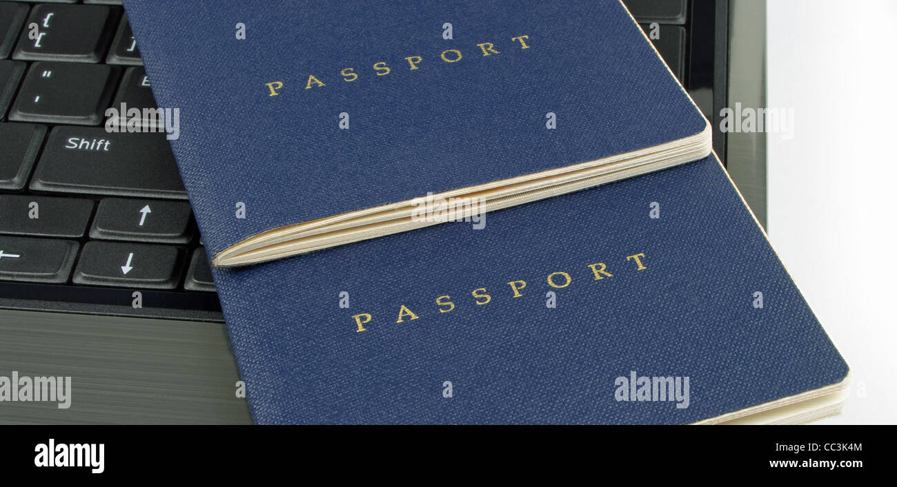 two blue passports on a computer keyboard Stock Photo - Alamy