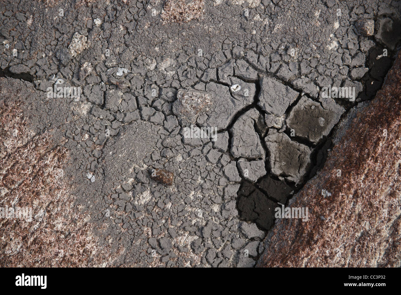 Cracked soil between rocks Stock Photo - Alamy