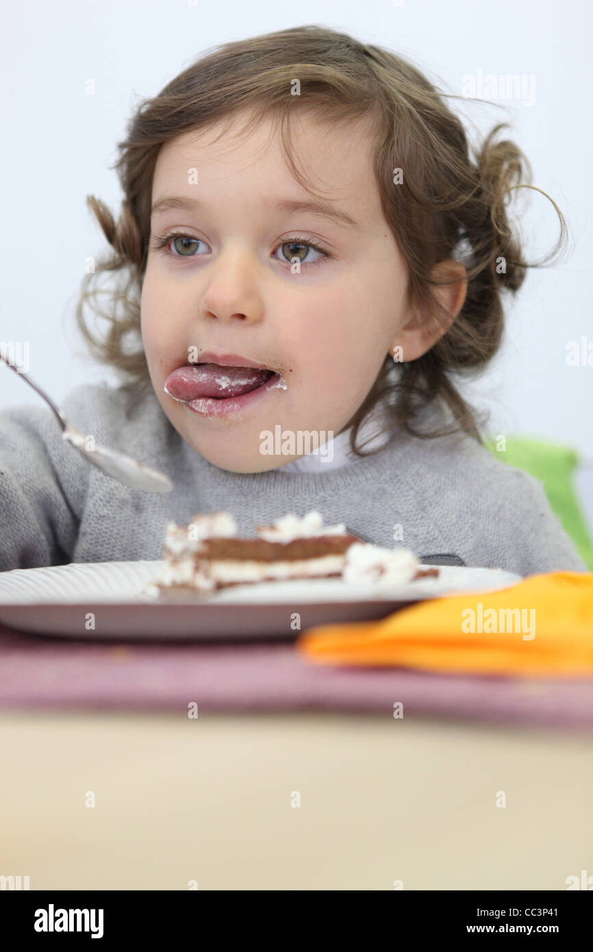 Young girl eating a piece of cake Stock Photo - Alamy