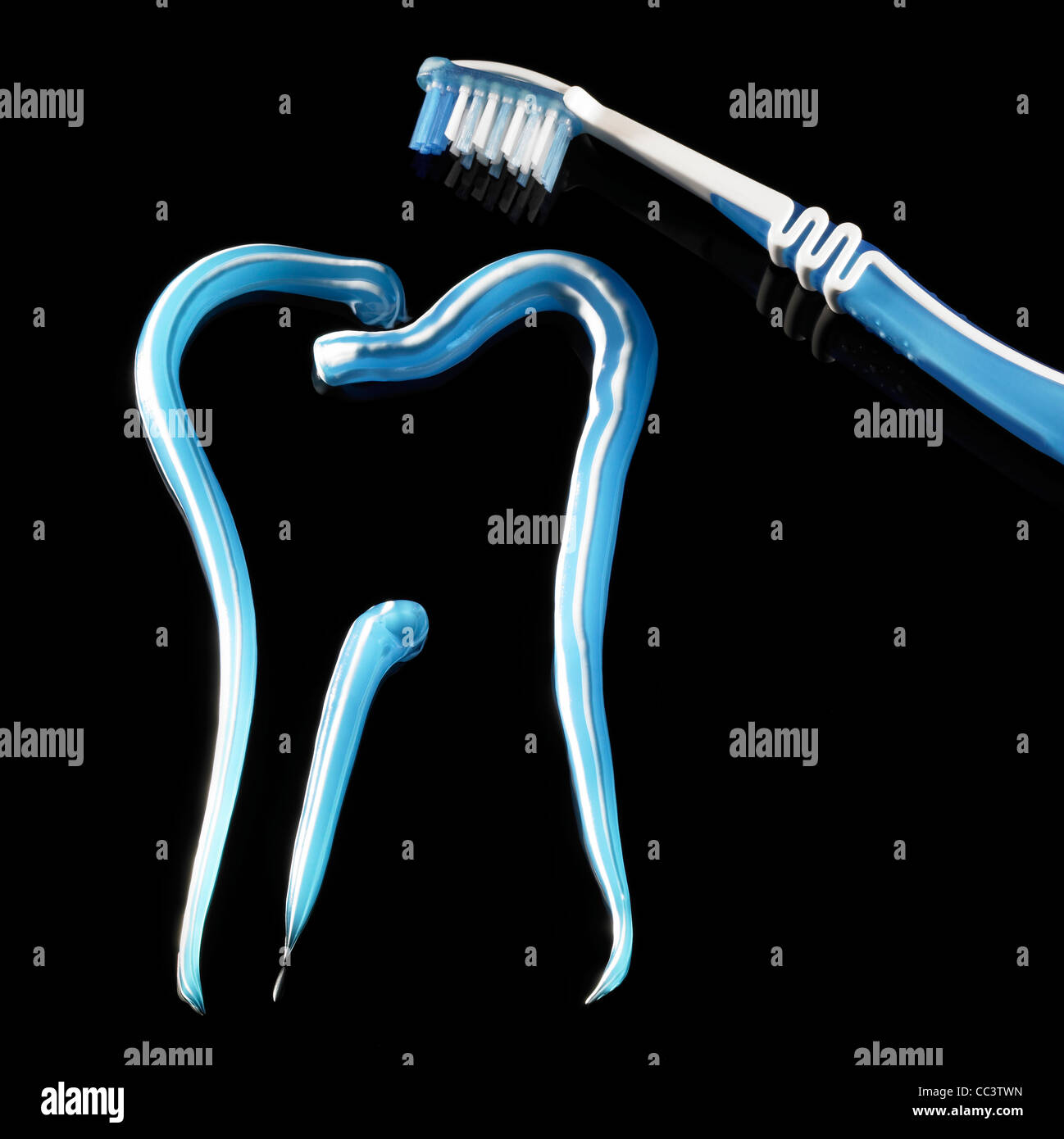 symbolic tooth painted with toothpaste and toothbrush on black ...