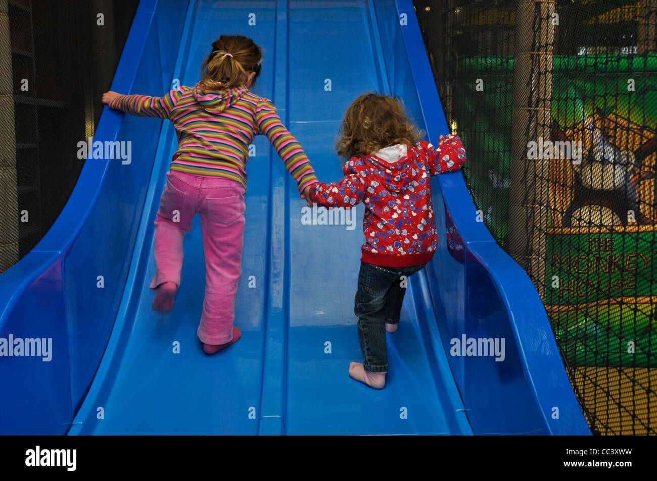 Two children attempting climb up hi-res stock photography and images ...