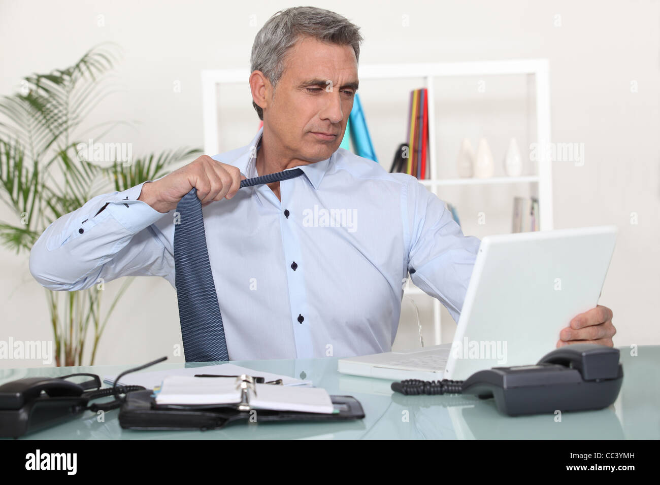 Man undoing his tie at the end of the day Stock Photo - Alamy