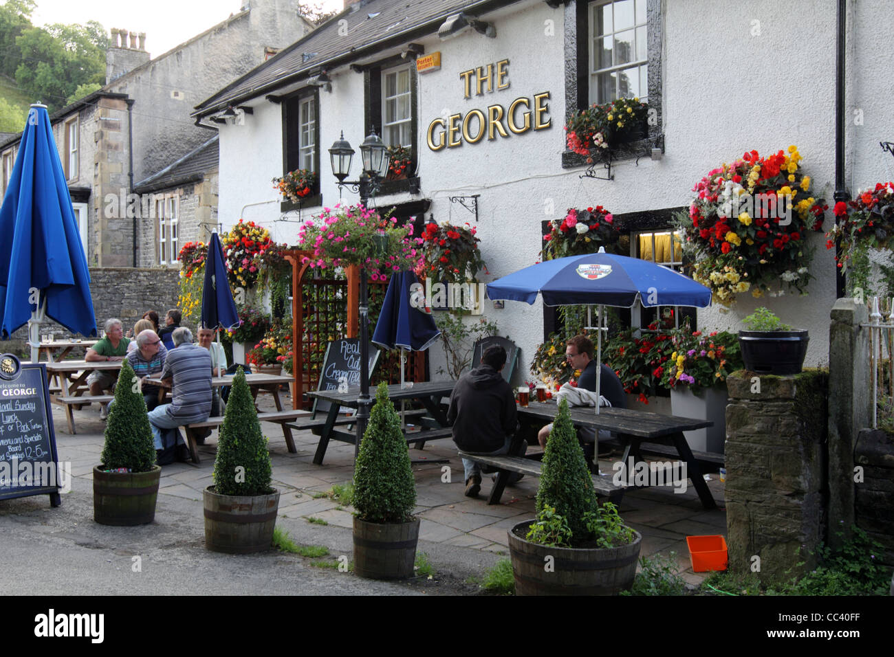 people sitting outside a British pub The George public house Castleton ...