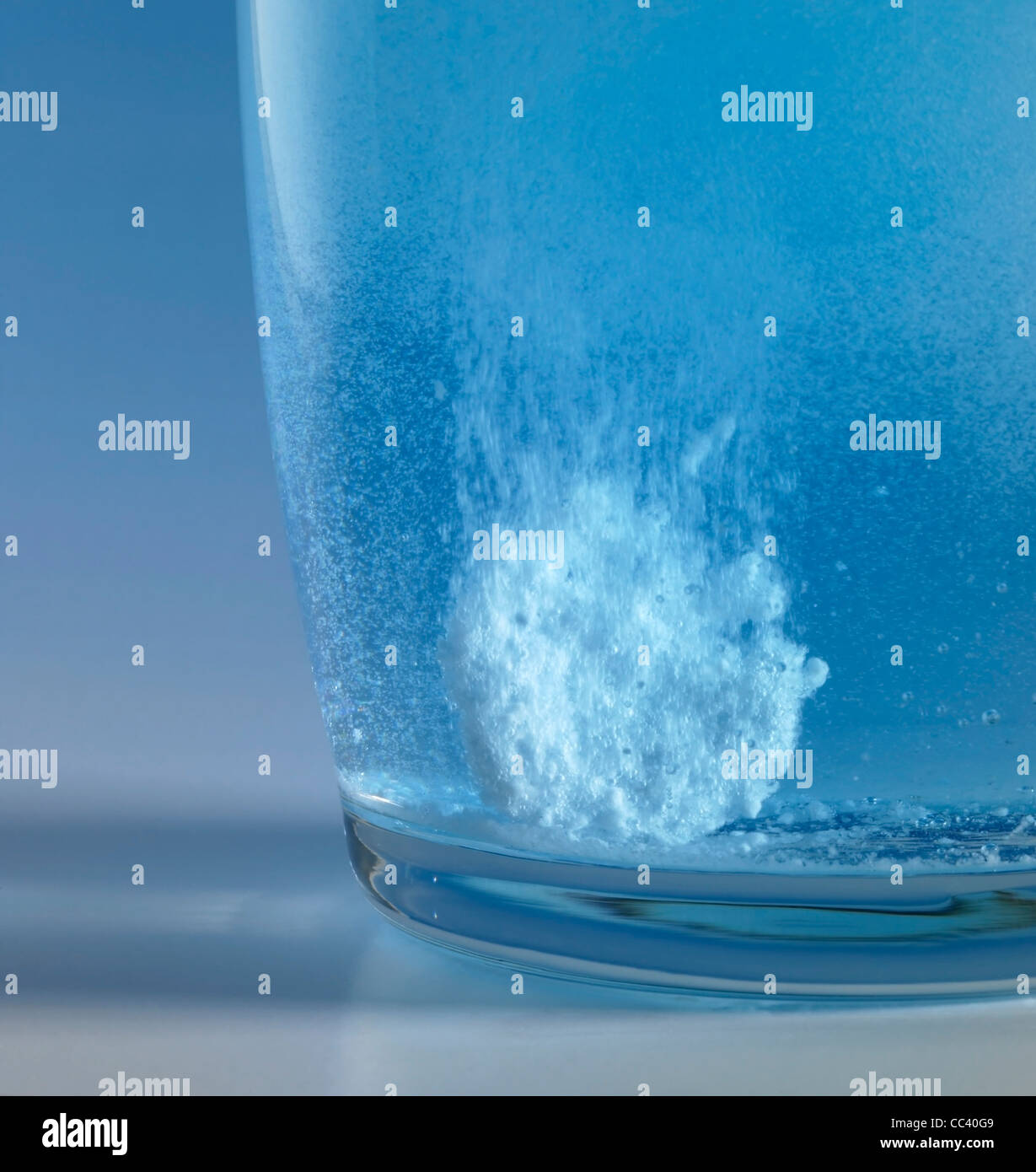 dissolving fizzy tablet floating in a glass of water. Studio ...