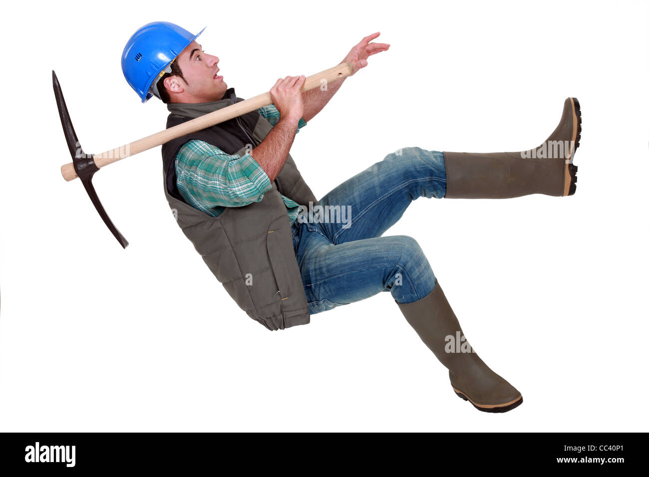 Man with pick-axe falling off chair Stock Photo - Alamy