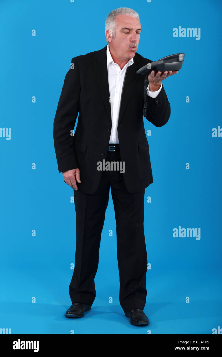 Man blowing dust off of a telephone Stock Photo - Alamy