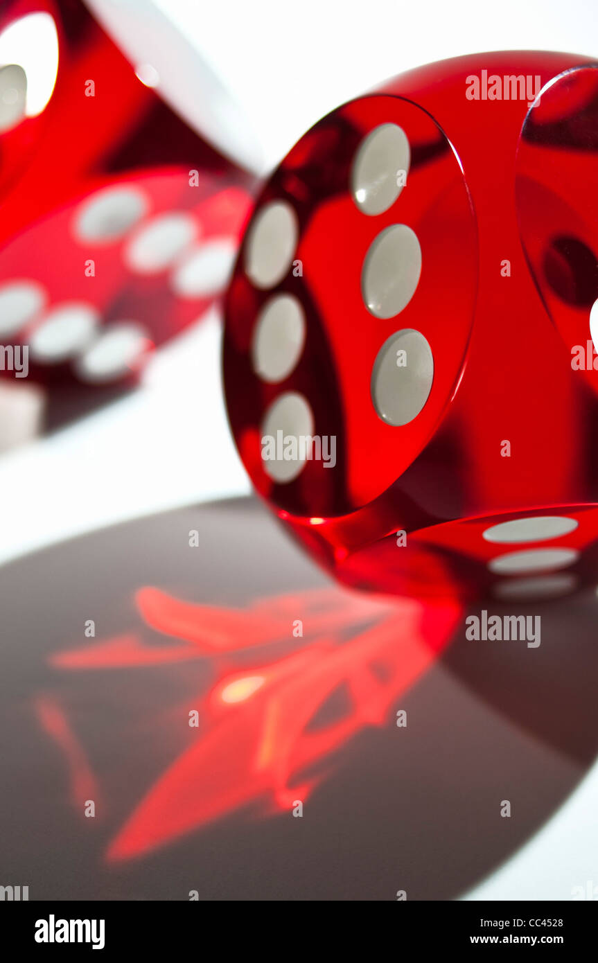 A close-up shot of red game dice rolling with light reflecting through ...