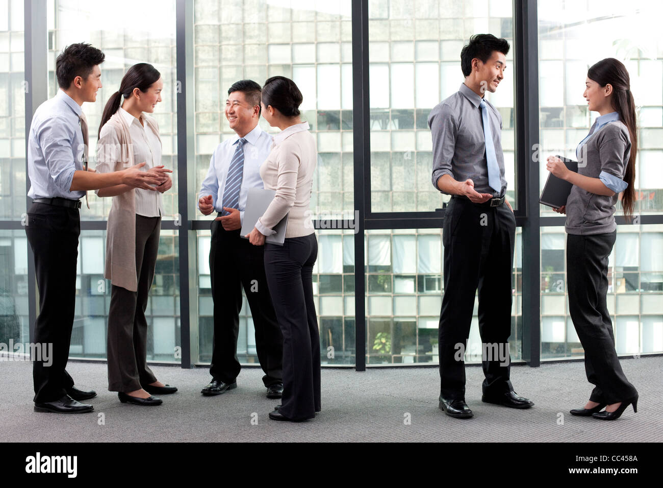 Businesspeople in different discussion groups Stock Photo - Alamy