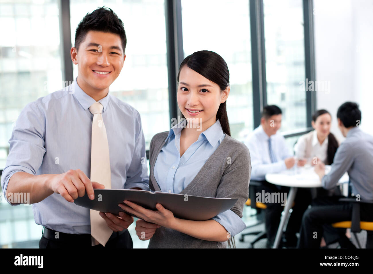 Businesspeople looking over documents Stock Photo - Alamy