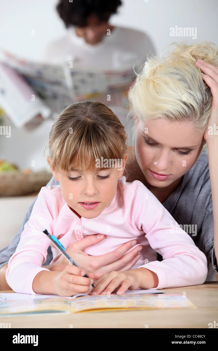 Baby-sitter and little girl doing homework Stock Photo - Alamy