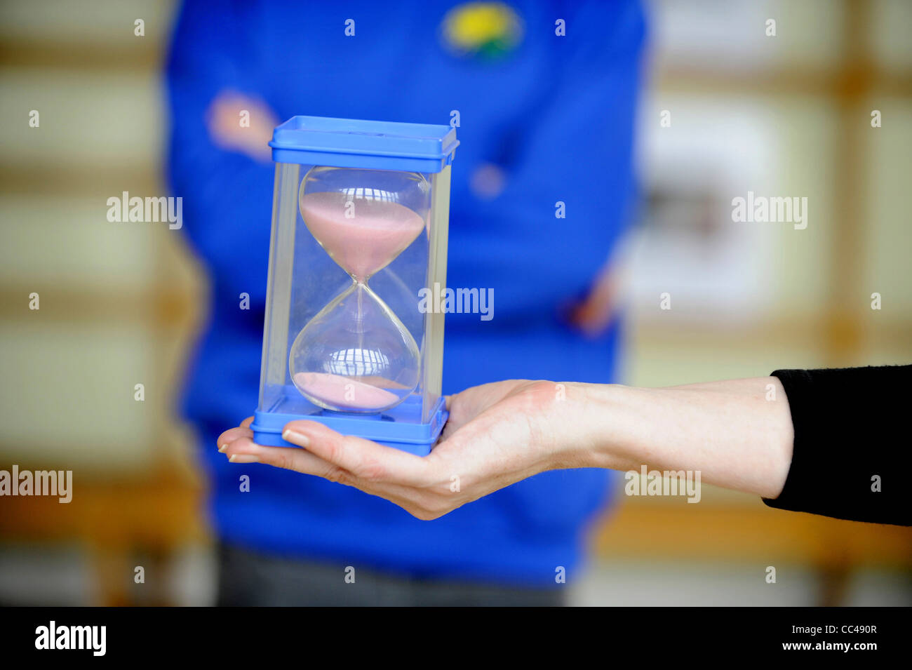 Time-out at school: An egg timer held out with school child out of ...