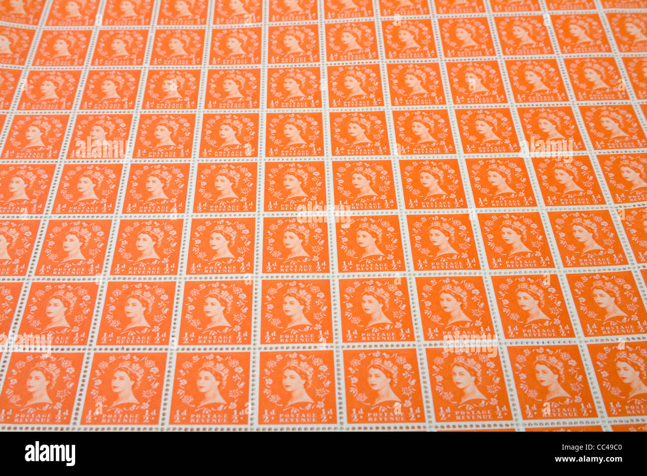 Close up sheet of orange old pre decimal British 1/2d postage stamps ...
