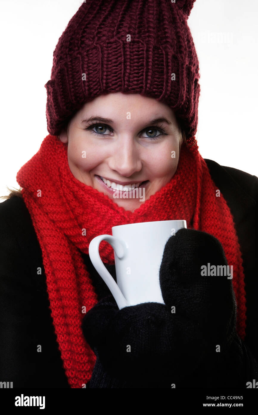 woman looking cold in winter clothes drinking a hot drink to keep warm ...