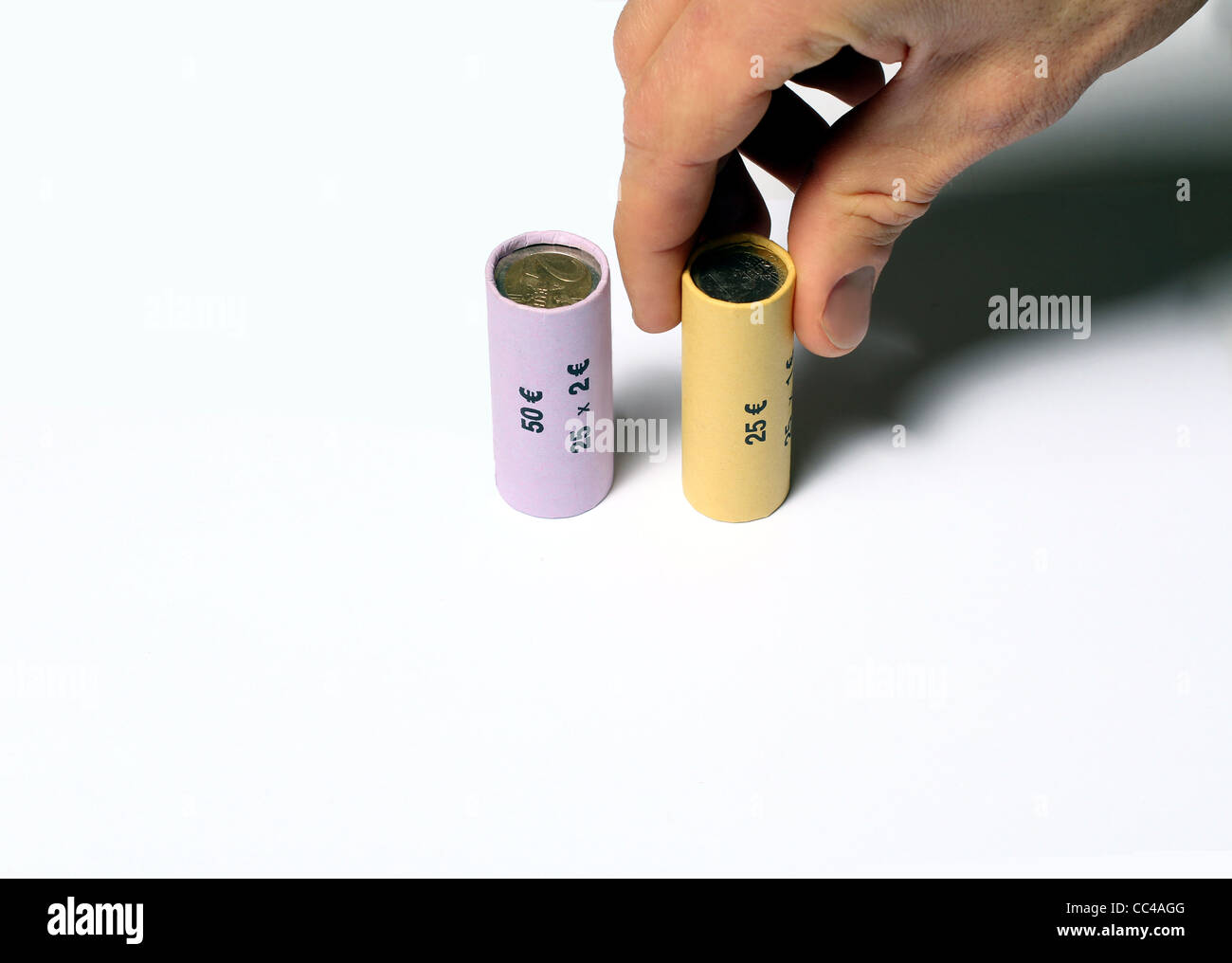 Hand grabbing one of two Euro coin rolls Stock Photo - Alamy
