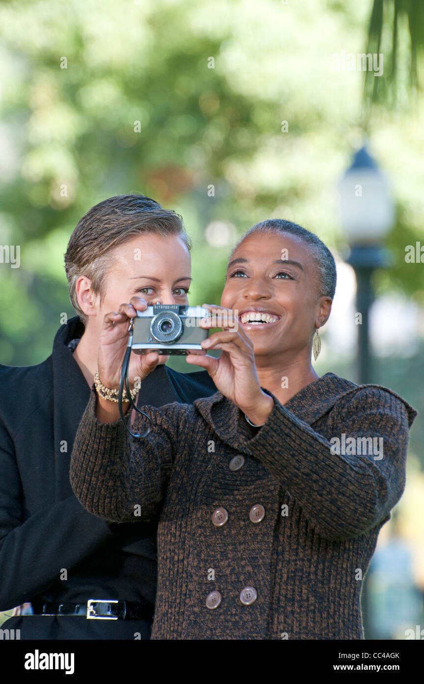 two middle aged woman have fun in the park taking photos Stock Photo ...