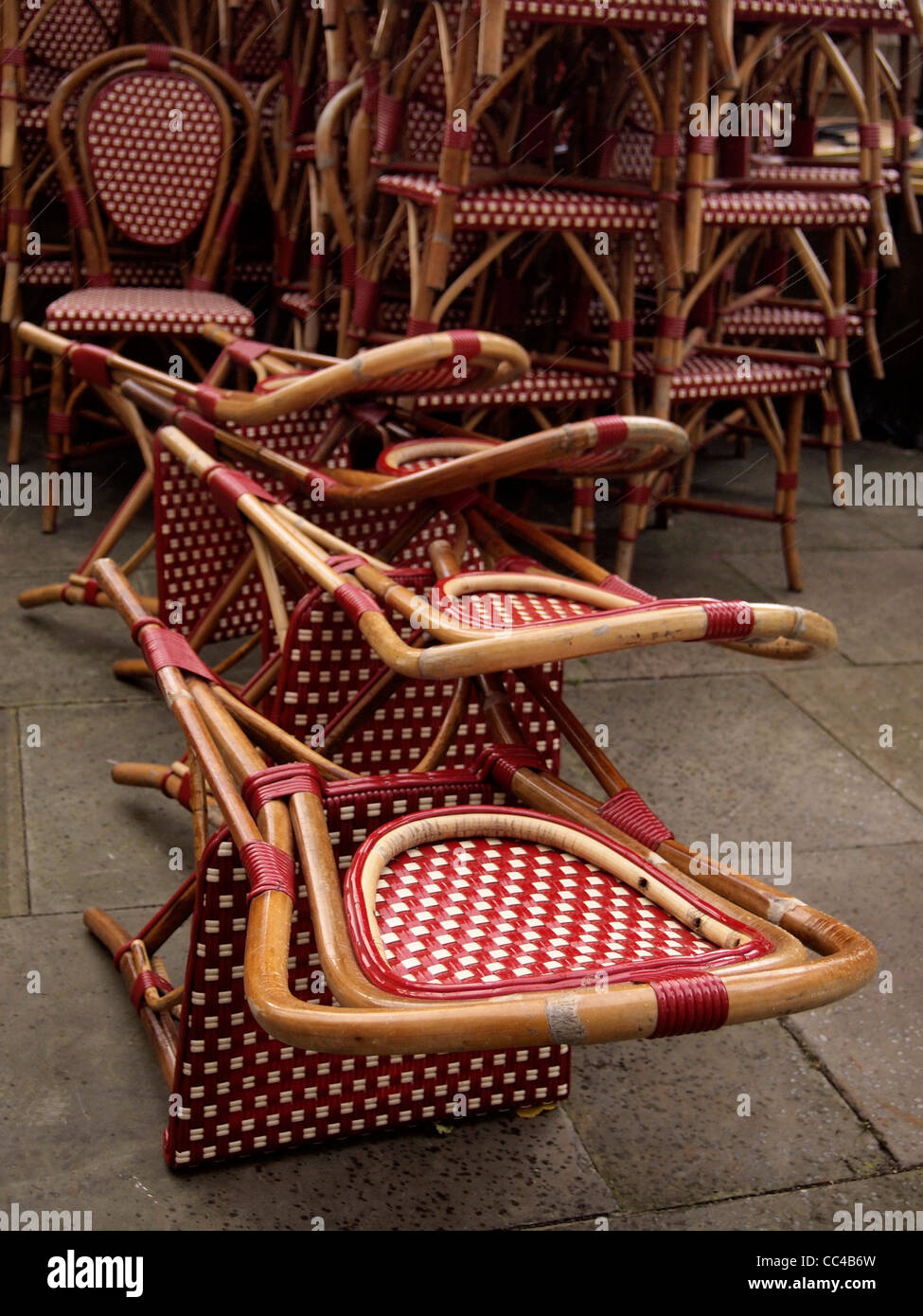 Collapsed stack of red and cream upholstered chairs outside restaurant ...