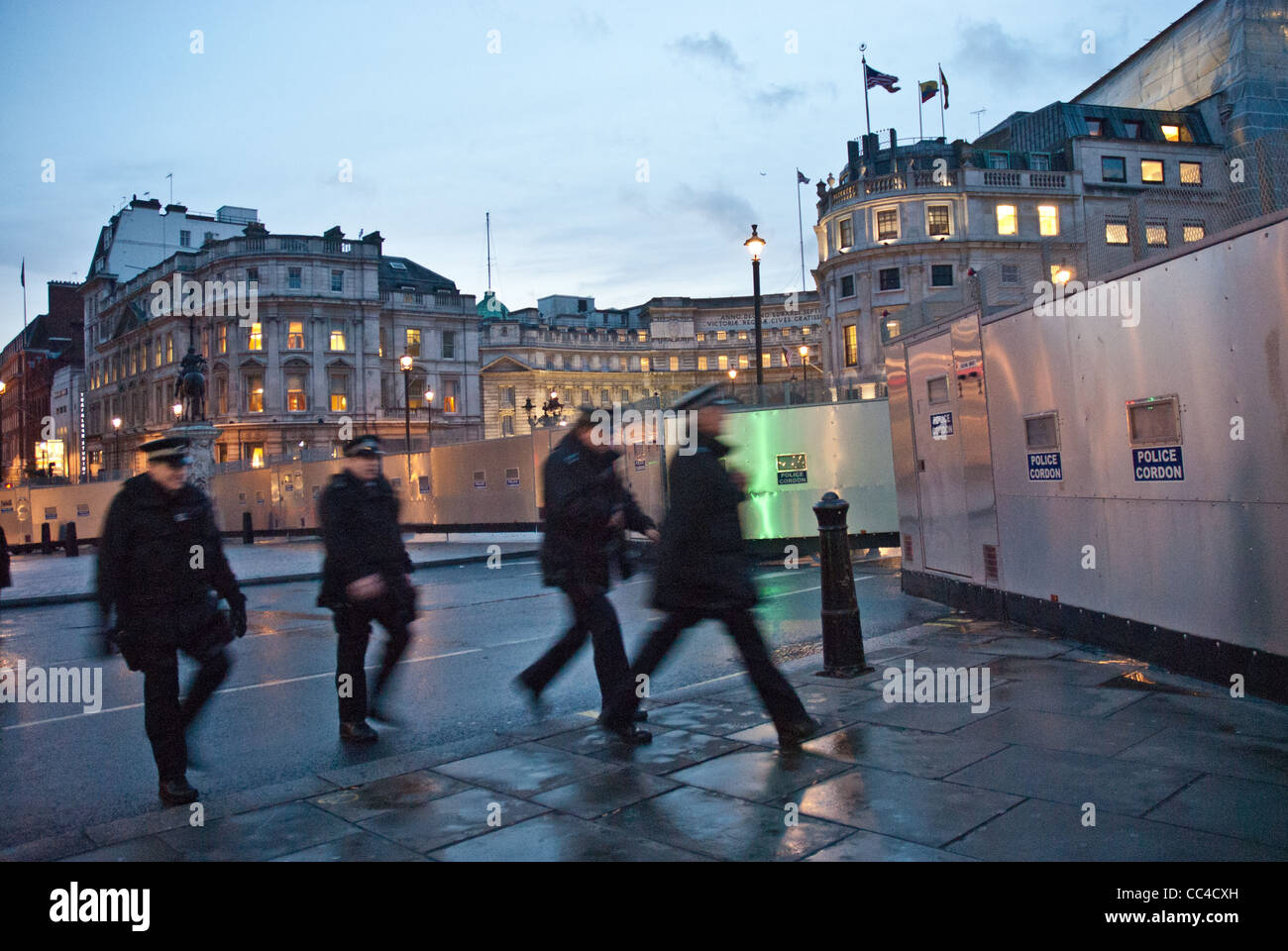 A group of police in uniform at dusk, blurred by movement, against a ...