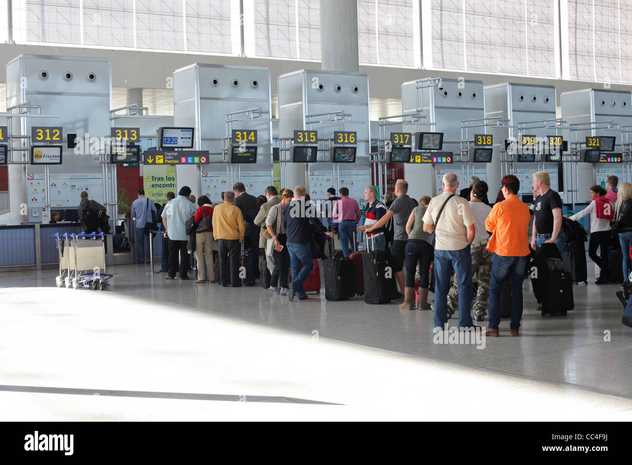 Tourists in a line to check in at Malaga Airport Stock Photo - Alamy
