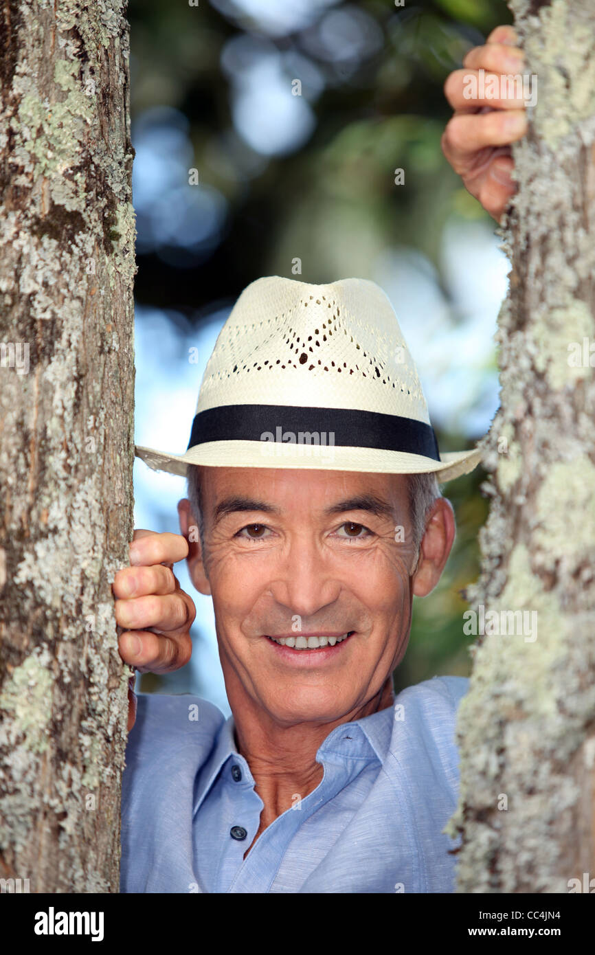 Senior man between two trees Stock Photo - Alamy