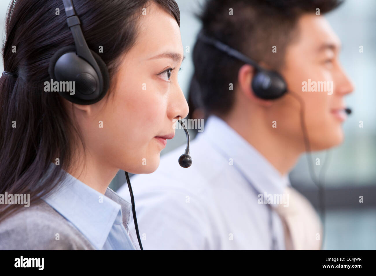 Side view of call center agents with headsets Stock Photo - Alamy