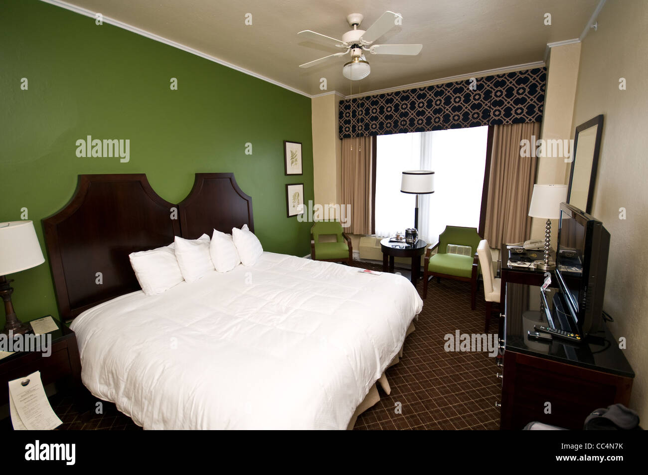 Nice hotel room with double queen bed and green wall Stock Photo - Alamy