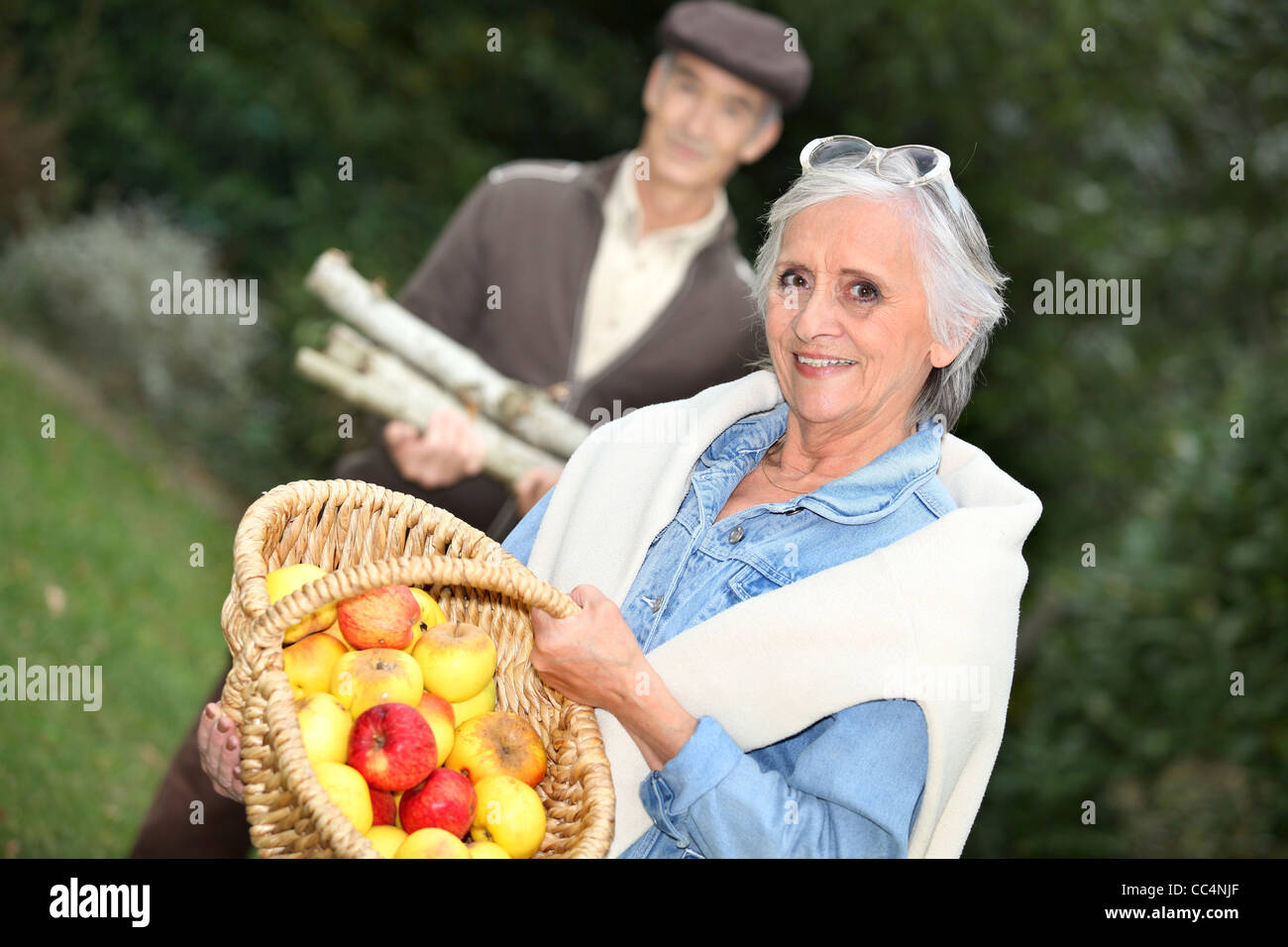 Elderly couple collecting objects in the forest Stock Photo - Alamy