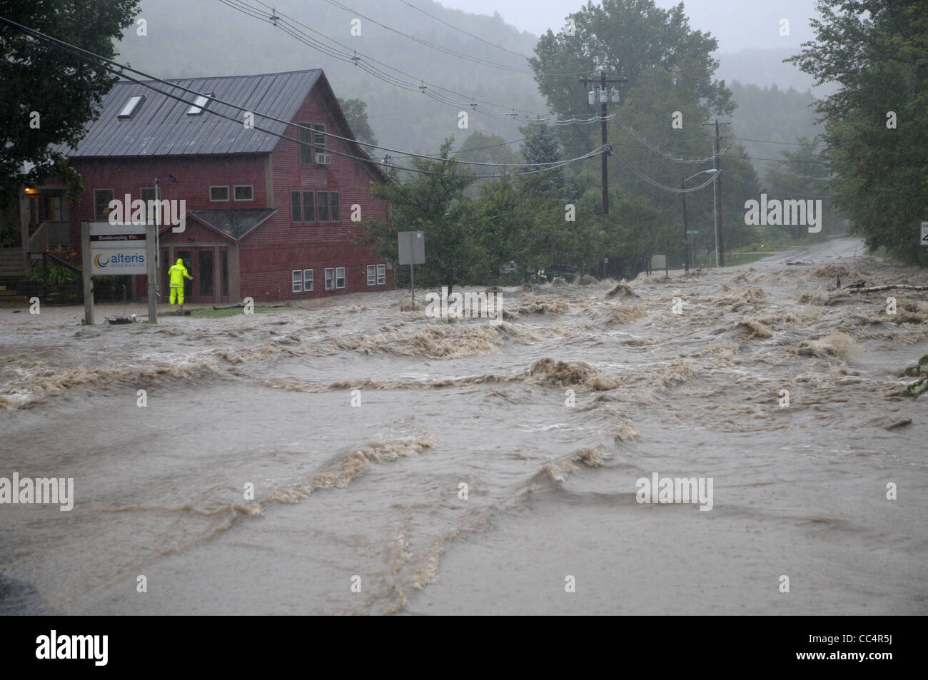 A rescuer searches a building as raging waters caused by tropical storm ...