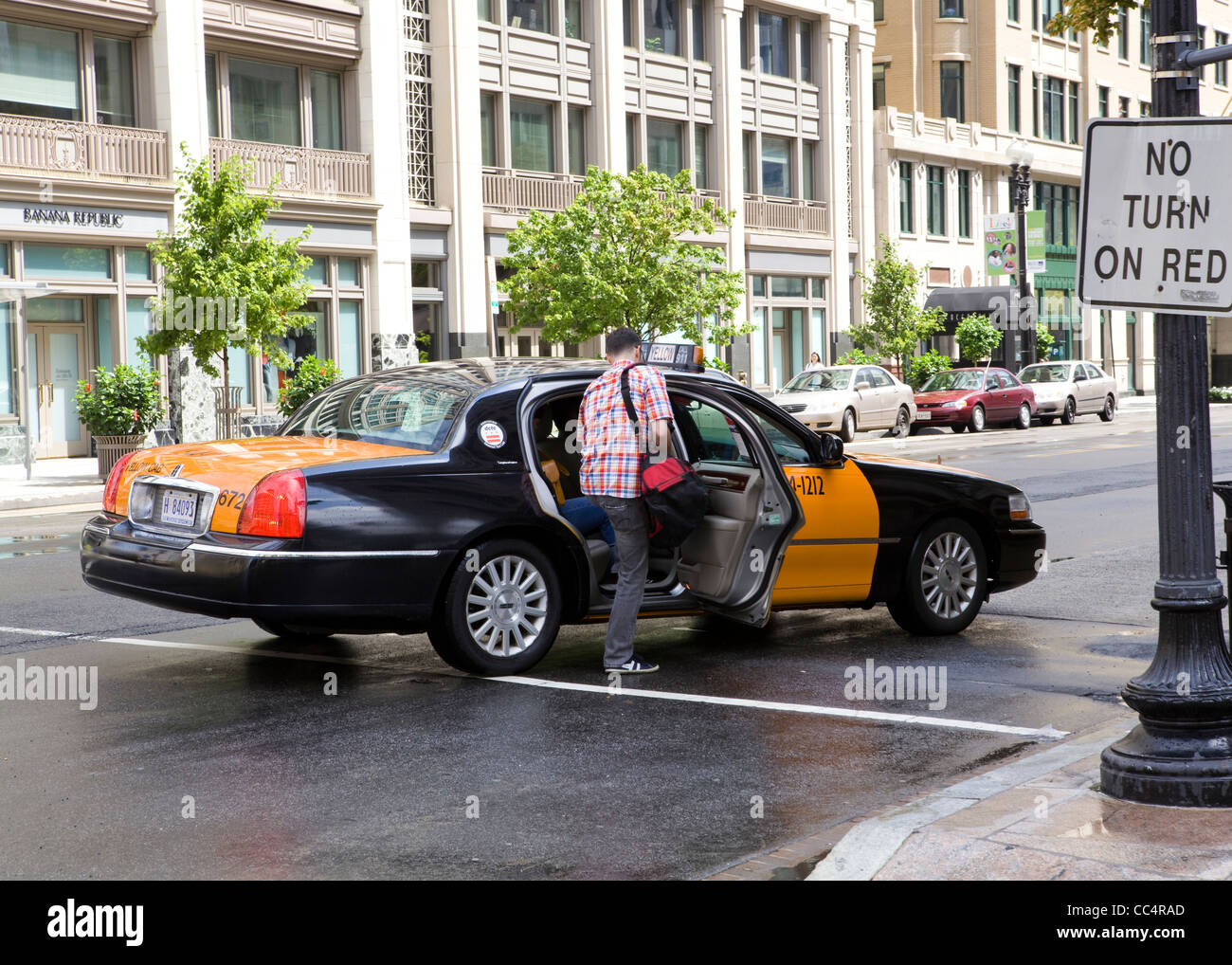 A man getting into a taxi during rainy weather - USA Stock Photo - Alamy