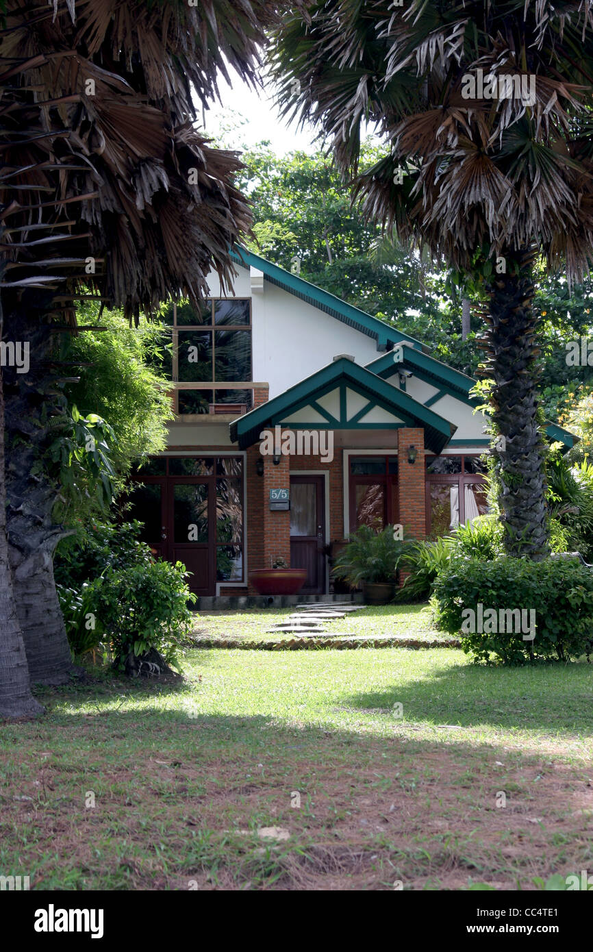 A beautiful oceanfront rural home with a green front yard stands in ...