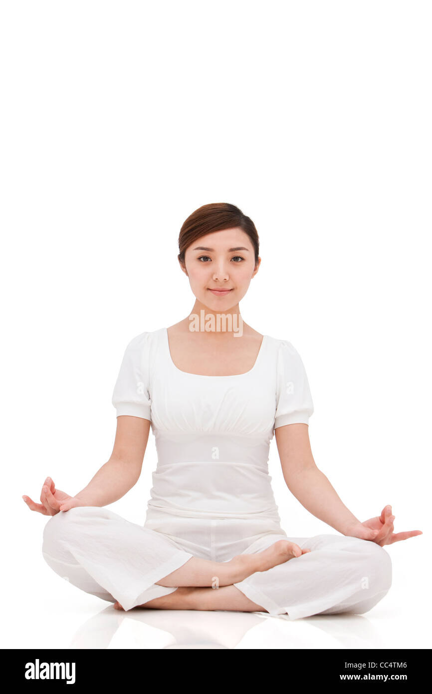 Young woman sitting and meditating Stock Photo - Alamy