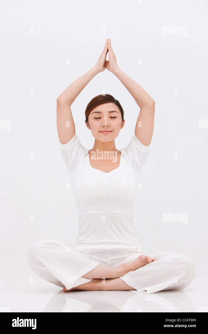 Young woman sitting and meditating Stock Photo - Alamy