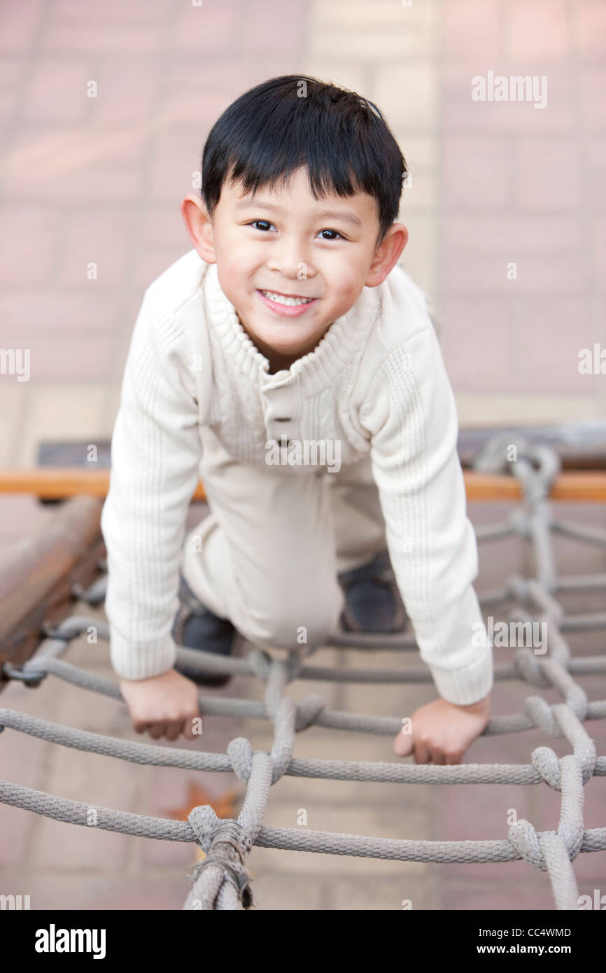 Boy climbing playground rope ladder Stock Photo - Alamy