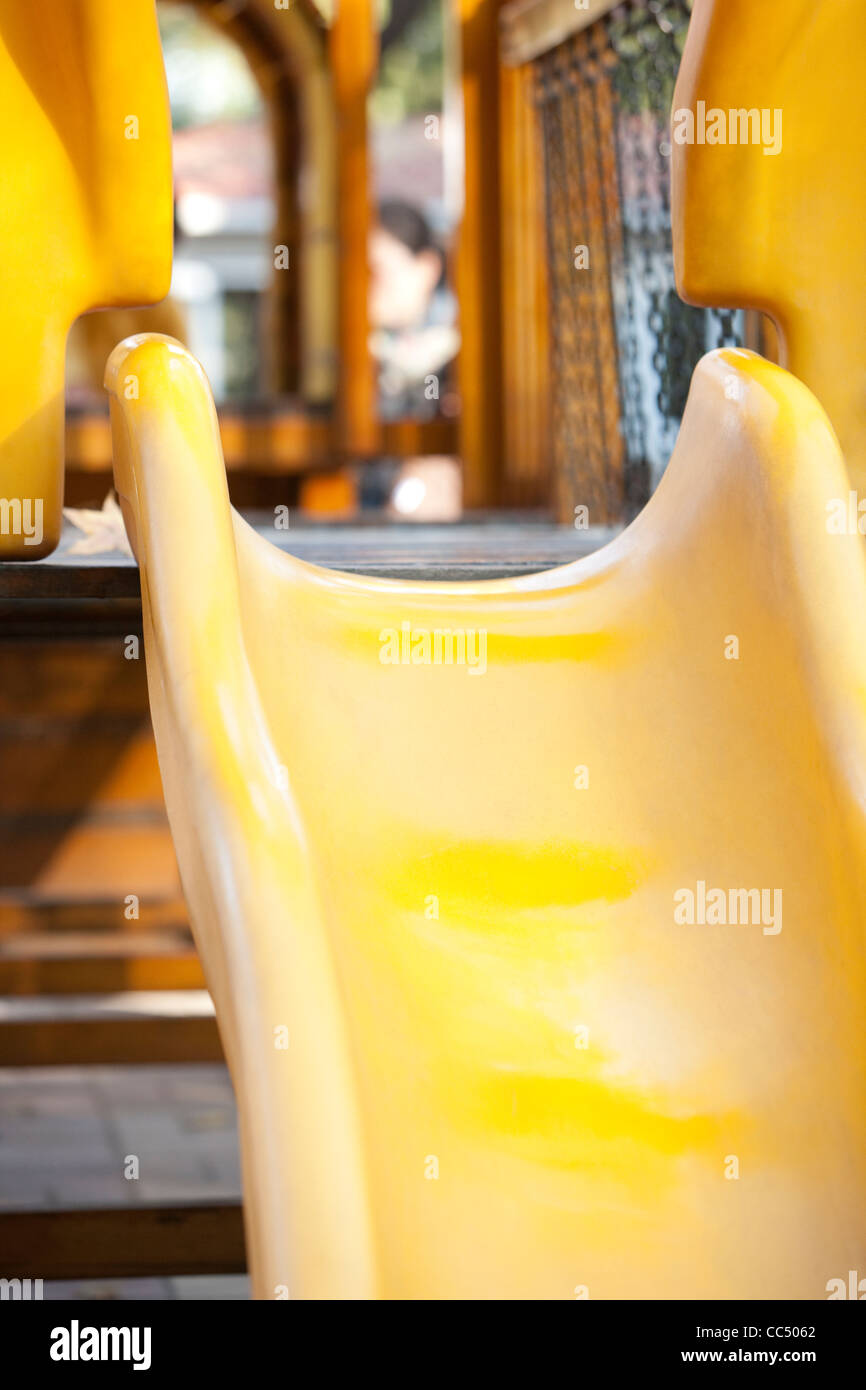 Yellow slide in playground Stock Photo - Alamy