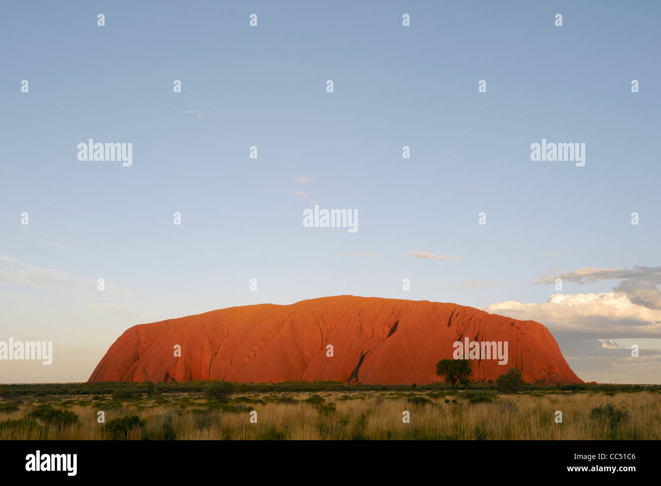 Sunset on Uluru; Ayers Rock glows orange under the setting sun, Uluru ...