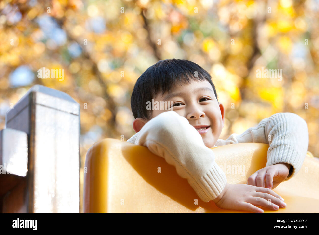 Boy playing on playground slide Stock Photo - Alamy