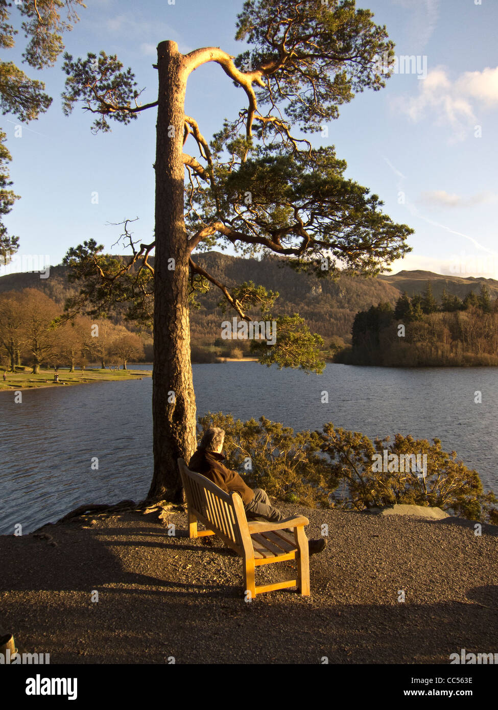 A man seated in the winter sunshine at the Friars Crag on Derwent Water ...