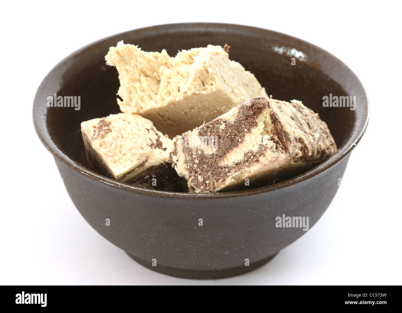 Typical Greek cacao halva dessert cut into two pieces in brown bowl ...