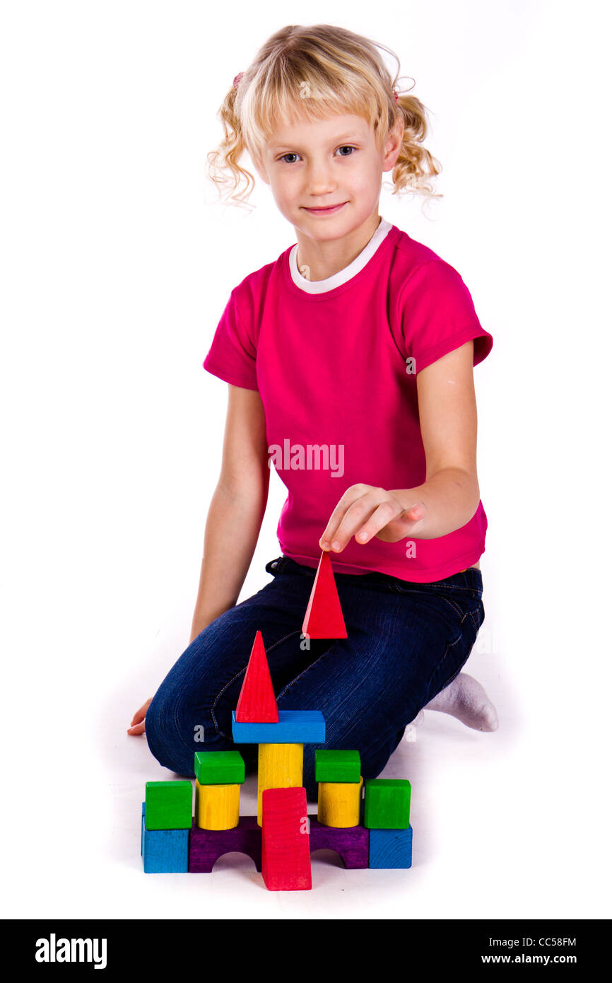 Beautiful girl building a castle with cubes isolated on white Stock ...