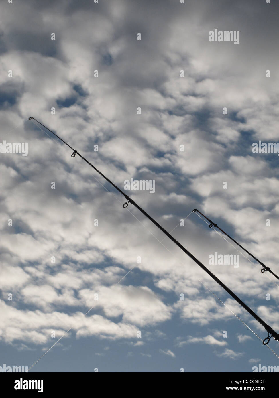 two fishing rods and cloudy sky Stock Photo - Alamy