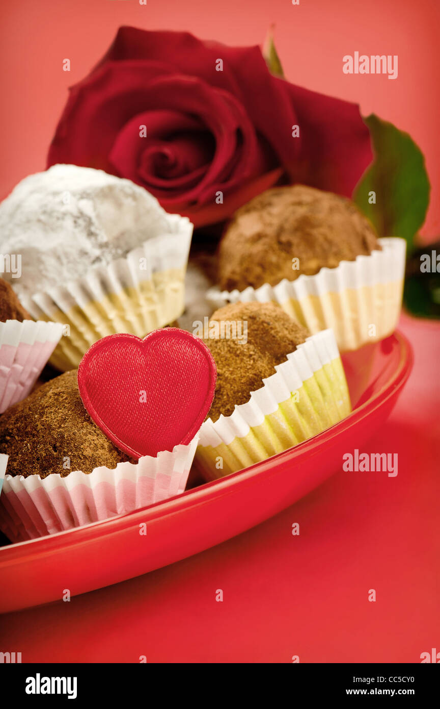 Valentine's chocolate truffles on red background Stock Photo - Alamy