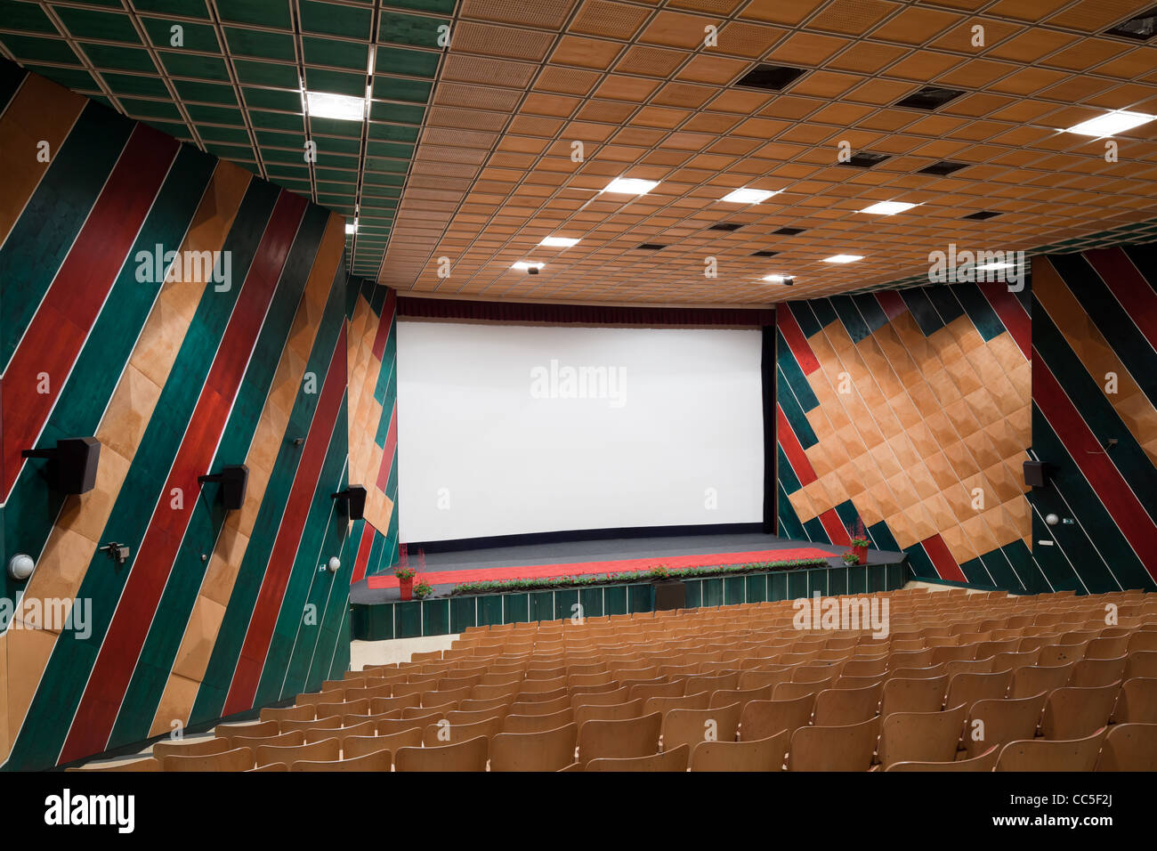 Empty cinema auditorium with line of chairs and projection screen ...