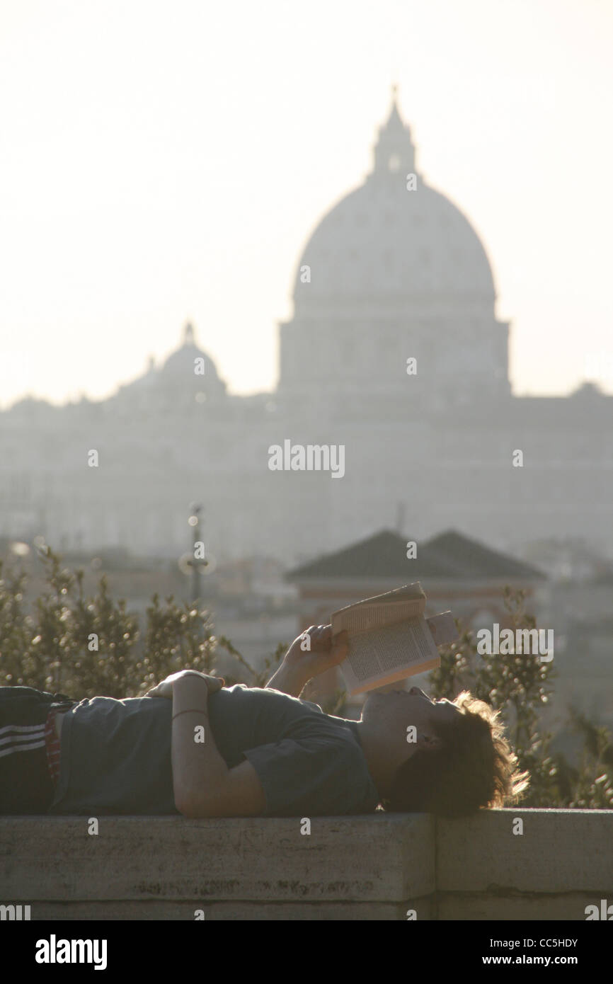 young man reading book on the pincio hill with vatican dome, rome Stock ...