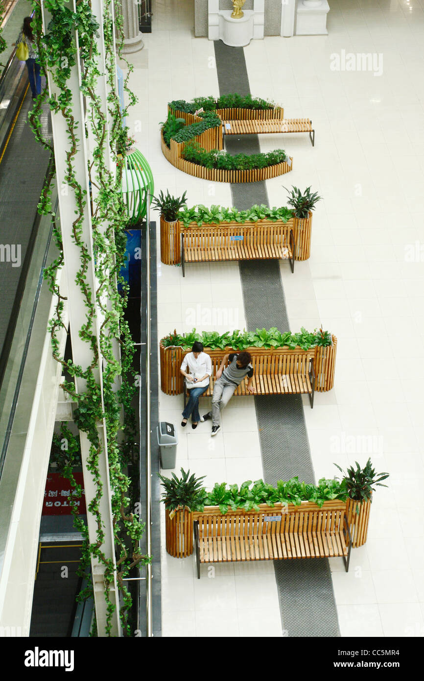 Couple resting on bench in a shopping mall, Changchun, Jilin , China ...