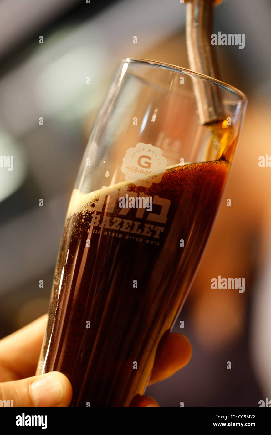 A beer glass displays the Israeli Bazelet microbrewery beer logo Stock ...