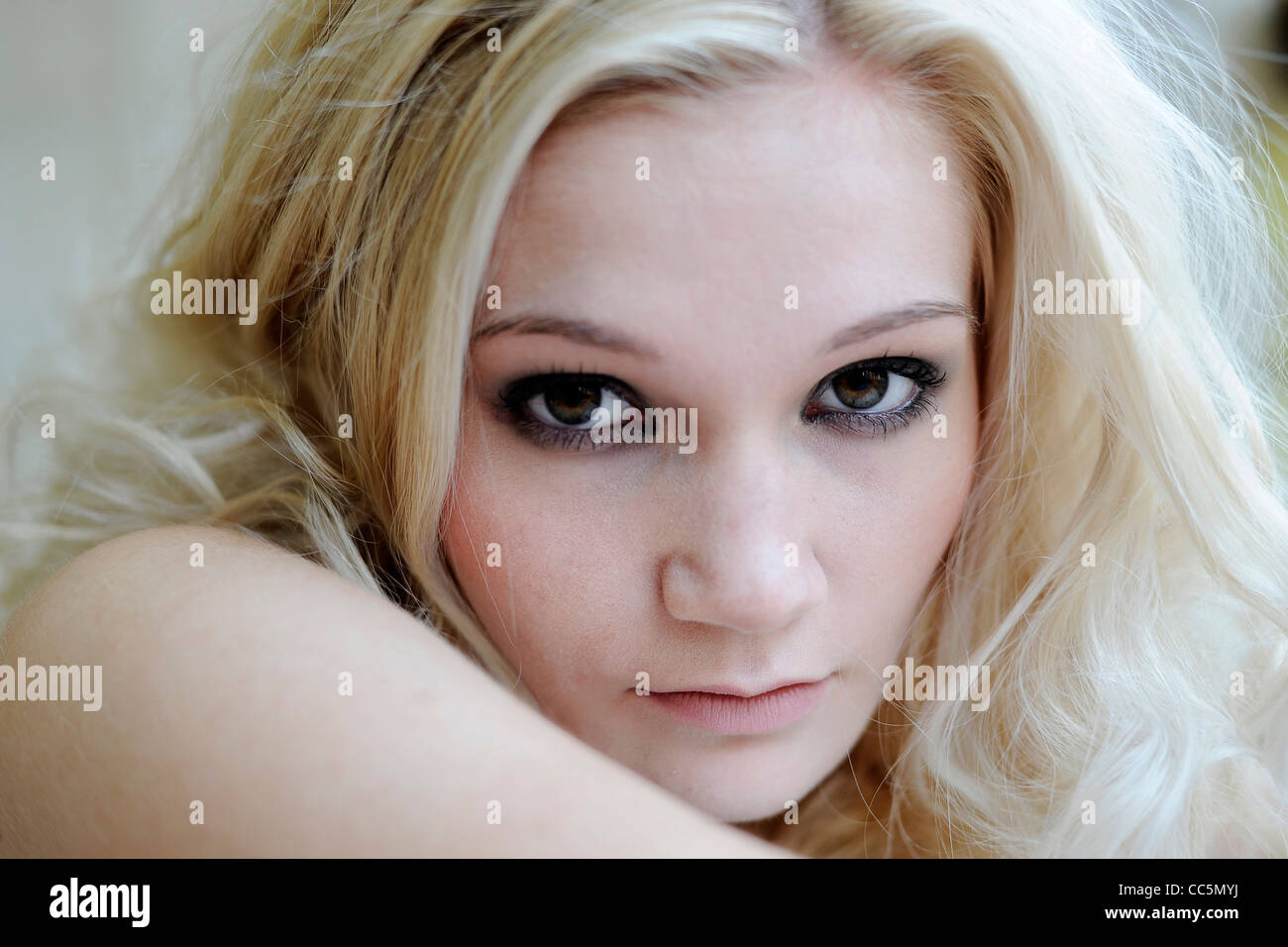 Fashion headshot of young blonde with make up shot in warehouse ...