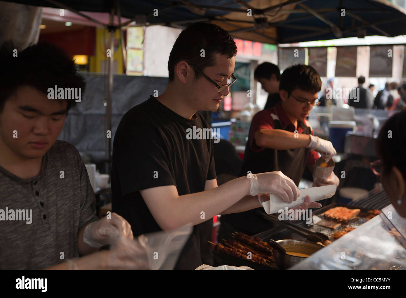 People work serving food on at the Chinese markets in the heart of ...