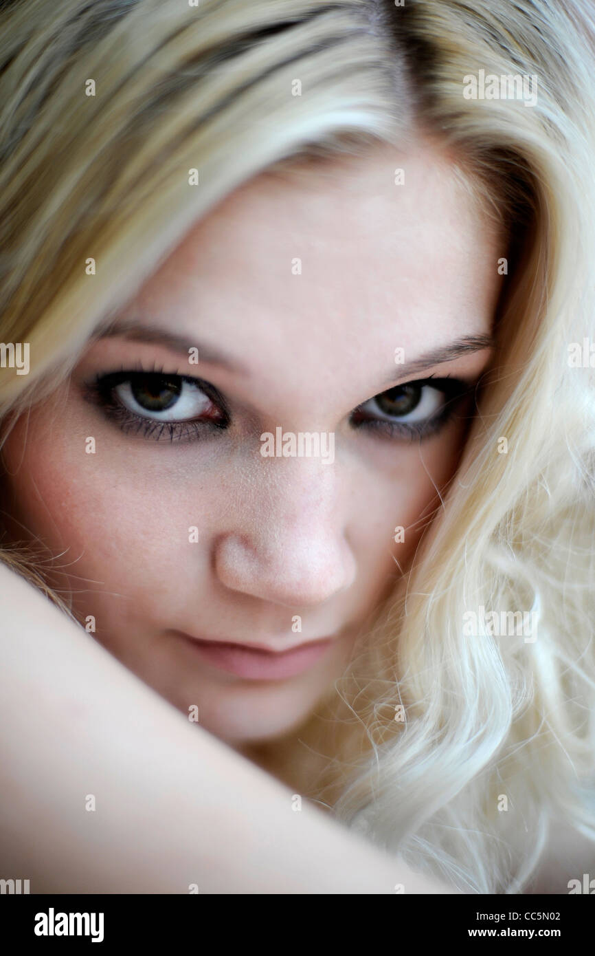 Fashion headshot of young blonde with make up shot in warehouse ...