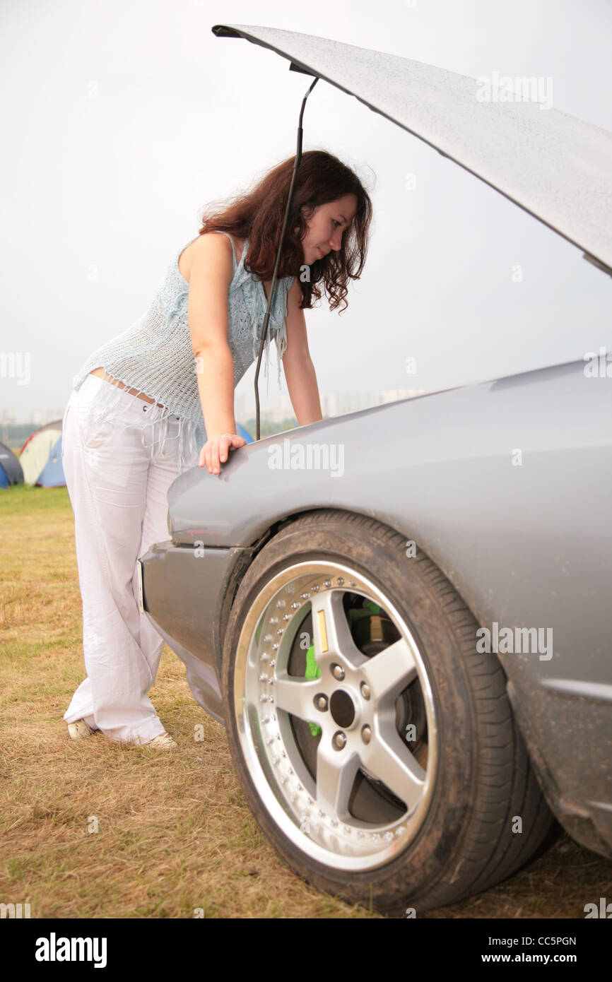 Beautiful woman looking under hood hi-res stock photography and images ...
