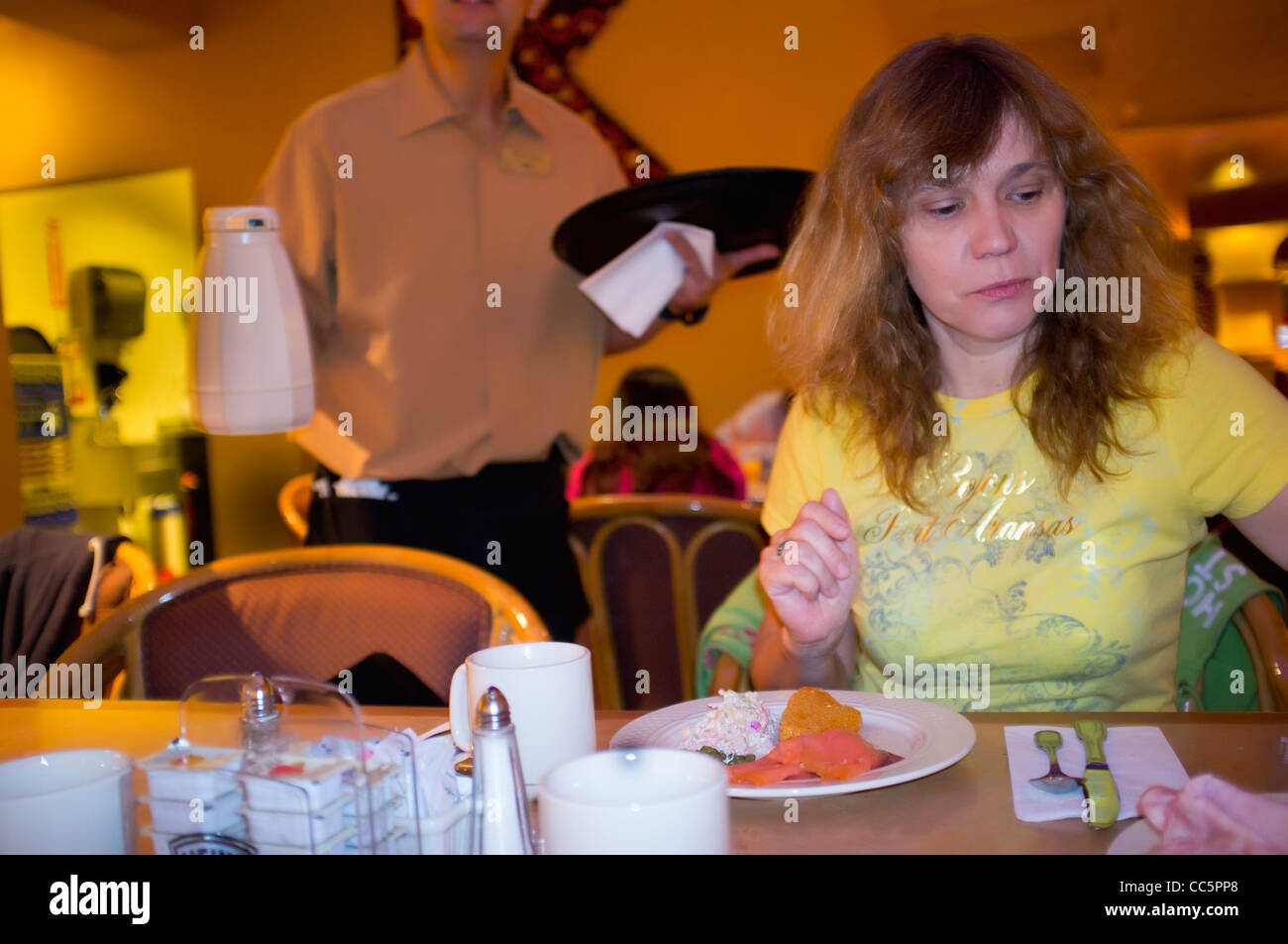 Woman eating breakfast at hotel restaurant, waiter with fresh coffee in ...